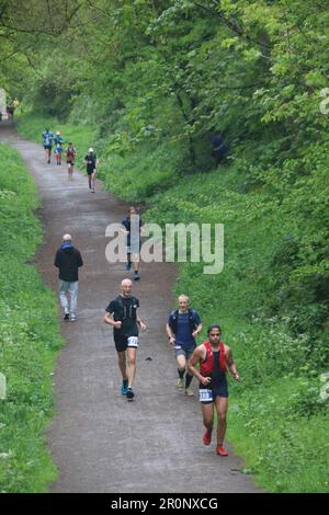 large group male and female runners run marathon city race in paving ...