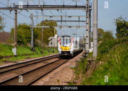 British Rail Class 720 Aventra of Greater Anglia passing at speed through countryside near ...