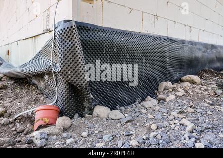 External house basement foundation wall insulation with rigid foam board before waterproofing ...