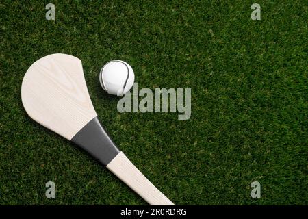 Hurling bat and sloitar on green grass. Horizontal sport theme poster ...