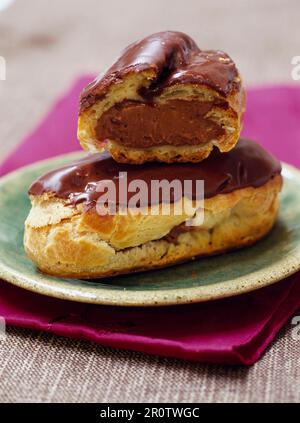 One half of a sweet chocolate eclair, close-up, isolated on a white ...