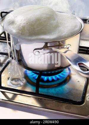 Milk boiling over a pan Stock Photo - Alamy