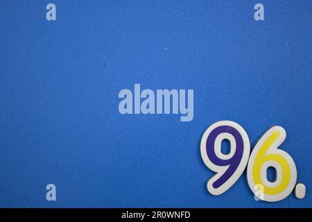 The number 96, placed on a blue background, photographed from above ...
