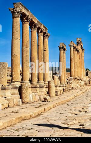 Ancient Roman colonnade street with stone pavement and clear blue sky ...