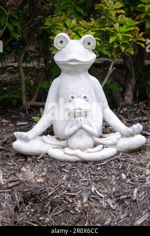 A garden ornament of 2 Buddhist frogs seated in the lotus position. In ...