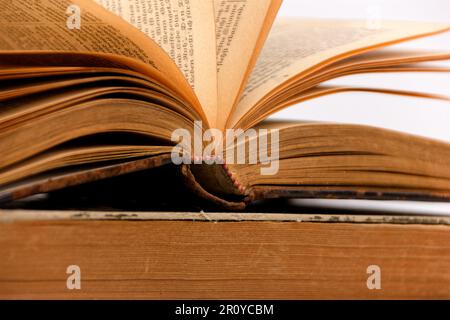 vintage old open book with some visible pages lying on top of other ...