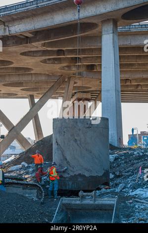 Workers and a pipe casing (caisson) for drilled shaft to support ...