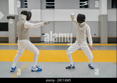 Two swordsmen exercising and fighting with rapiers during fencing ...