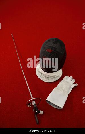 Fencing equipment concept, crossed swords and protective helmet with ...