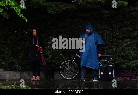 People seek shelter from a heavy rain shower on the southside of Dublin ...