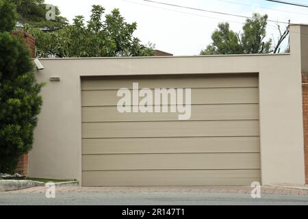 Beige garage with closed sectional door. Exterior design Stock Photo ...