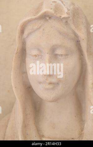 Cast model of serene woman with head covering and eyes lowered in ...