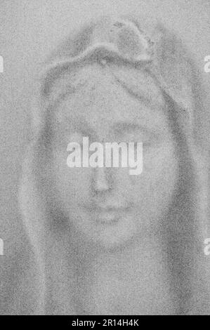 Cast model of serene woman with head covering and eyes lowered in ...
