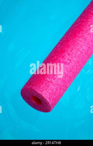 pink pool noodle floating on the blue water Stock Photo - Alamy
