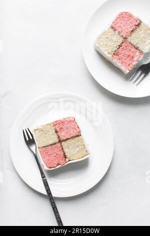 Top view of battenburg cake slice in a white plate, almond and ...