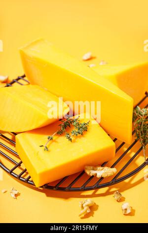 Stand with pieces of Swiss cheese and walnut on grey background Stock ...