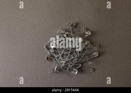 Pile of safety pins on grey textured background, flat lay Stock Photo ...