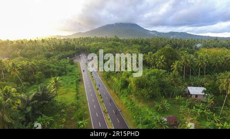Aerial photo of the highway dividing the forest and villages with a ...