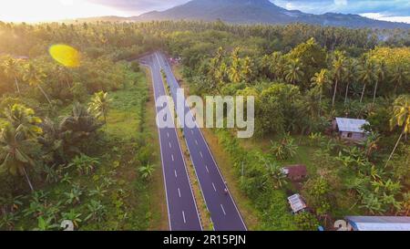 Aerial photo of the highway dividing the forest and villages with a ...