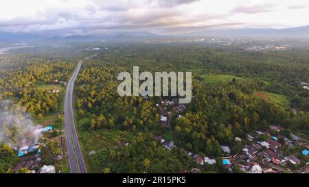 Aerial photo of the highway dividing the forest and villages with a ...