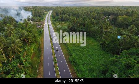 Aerial photo of the highway dividing the forest and villages with a ...