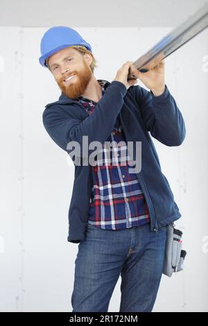 workman carrying a metal frame Stock Photo - Alamy