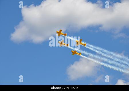Four yellow planes at airshow with smoke in cloudy sky Stock Photo - Alamy