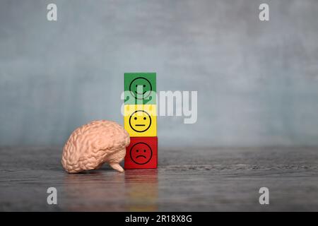 Brain and wooden cubes with happy, neutral and sad face. Mental health ...