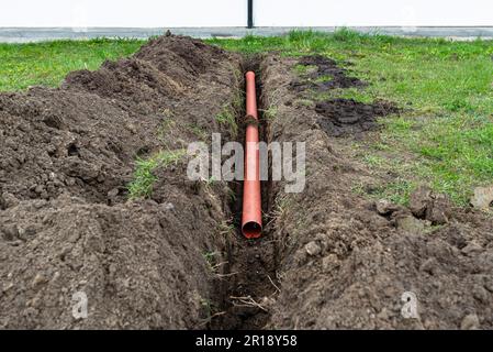 Laying drainage pipe for rain water on car parking lot is covered ...