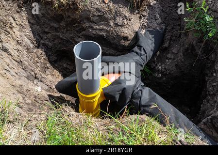Overflow and infiltration well connected to drainage pipes, buried in a ...