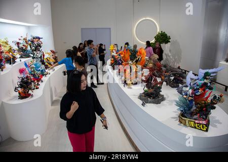 Visitors observe a collection of superhero statues at Statue4Heroes ...