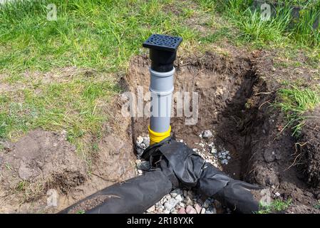 Overflow and infiltration well connected to drainage pipes, buried in a ...