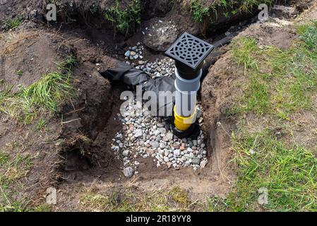 Overflow and infiltration well connected to drainage pipes, buried in a ...