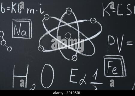 Different chemical formulas written with chalk on blackboard, closeup ...