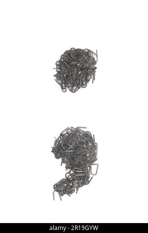 artistic isolated punctuation colon made from steel staples isolated on ...