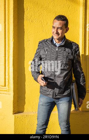 Hispanic man standing over yellow background smiling cheerful ...