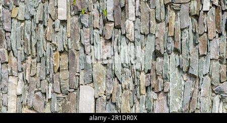 A fence made of stone plates as a background. Stone background. The ...