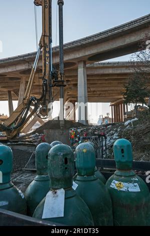 Oxygen tanks are in the foreground with a drilling rig for digging ...