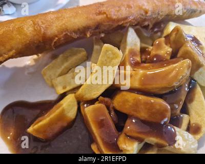 Unappetizing meal of fish and chips with gravy Stock Photo - Alamy