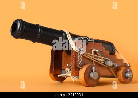 Toy model of cannon on orange background Stock Photo - Alamy