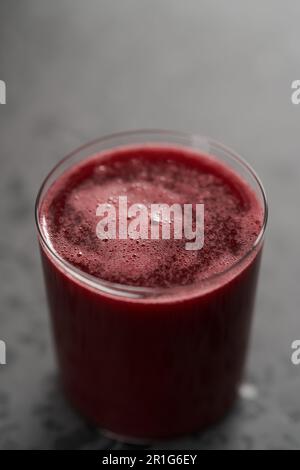 Glass of berry juice on concrete countertop, shallow focus Stock Photo ...