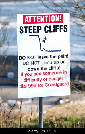 Steep cliffs warning sign for tourists high above Stonehaven harbour ...