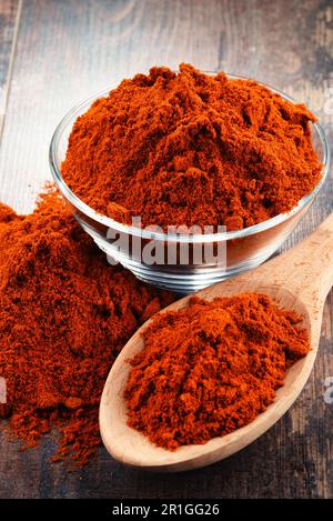 Composition with bowl of chili powder on wooden table Stock Photo - Alamy