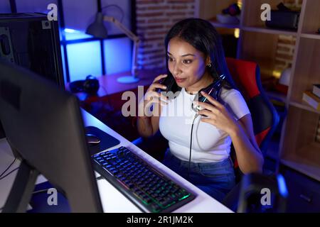 Young arab woman streamer sitting table with serious expression at ...