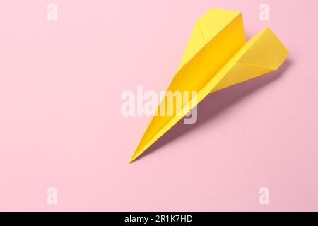 Yellow paper plane on pink background Stock Photo - Alamy