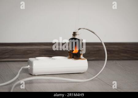 Inflamed plug in power strip indoors. Electrical short circuit Stock ...