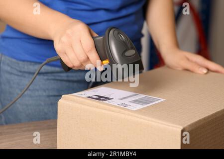 Post office worker with scanner reading parcel barcode at counter Stock ...