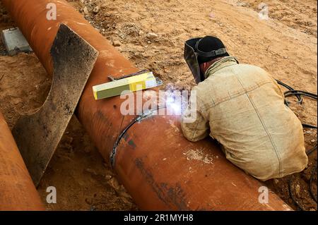 The welder welds the pipe by electro welding Stock Photo - Alamy
