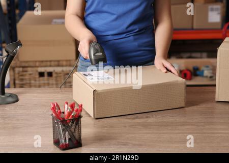 Post office worker with scanner reading parcel barcode at counter Stock ...