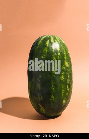 Melon stand on a beige color with a sharp shadow Stock Photo - Alamy
